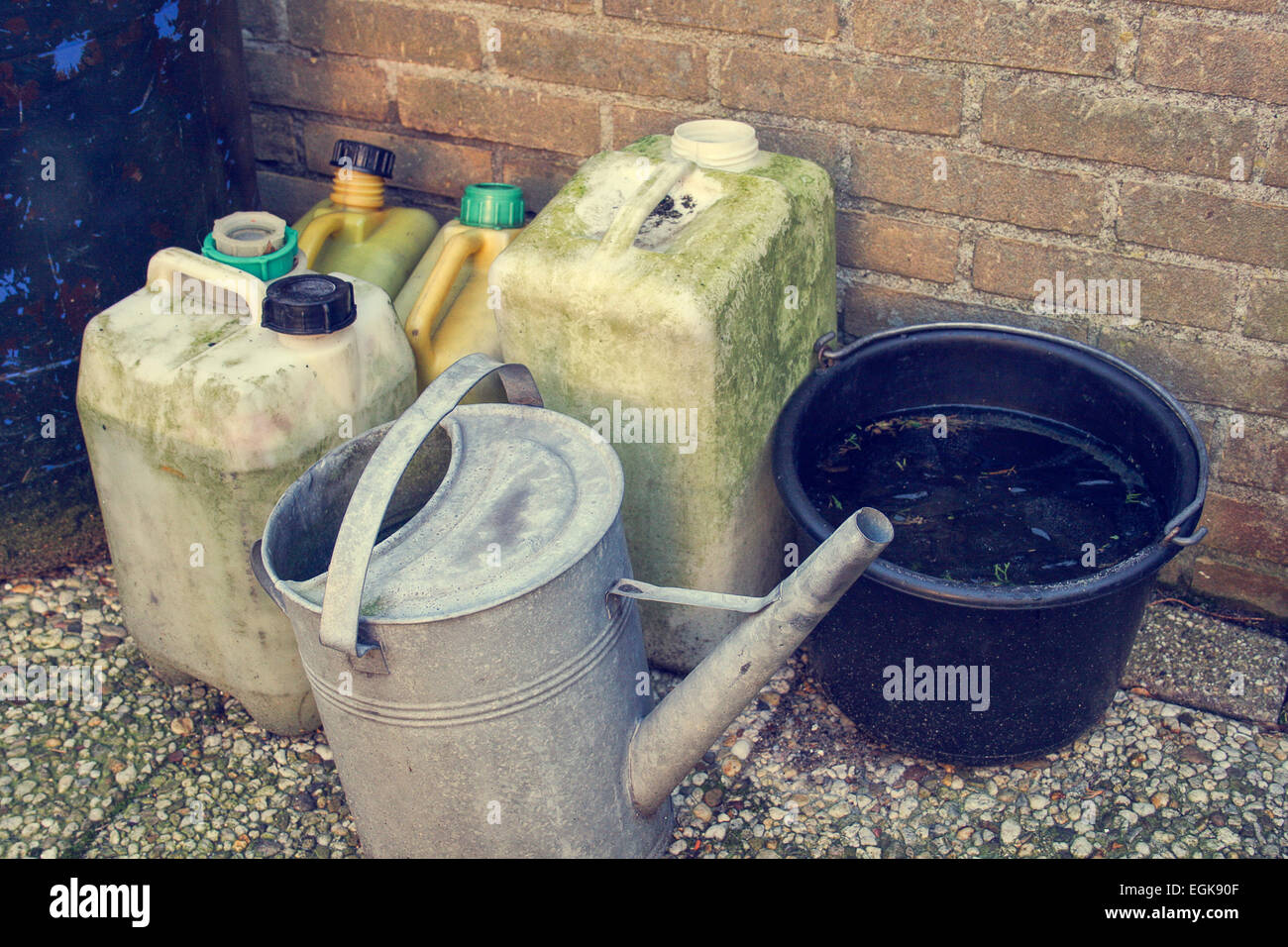 Buckets and containers with water to water the garden Stock Photo - Alamy