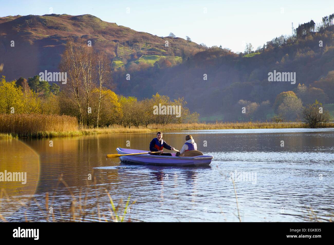 Couple boating on Grasmere Lake District National Park Cumbria England ...