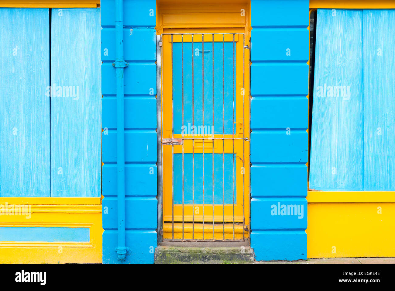 A colourful blue and yellow painted run down, closed shop in Brighton ...