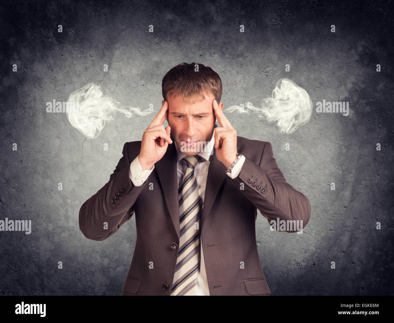 Stressed businessman thinking with his fingers on temples, smoke from ...