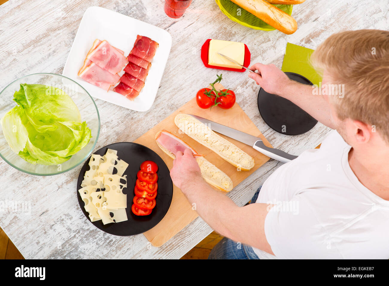 A young man preparing a sandwich in the kitchen Stock Photo - Alamy