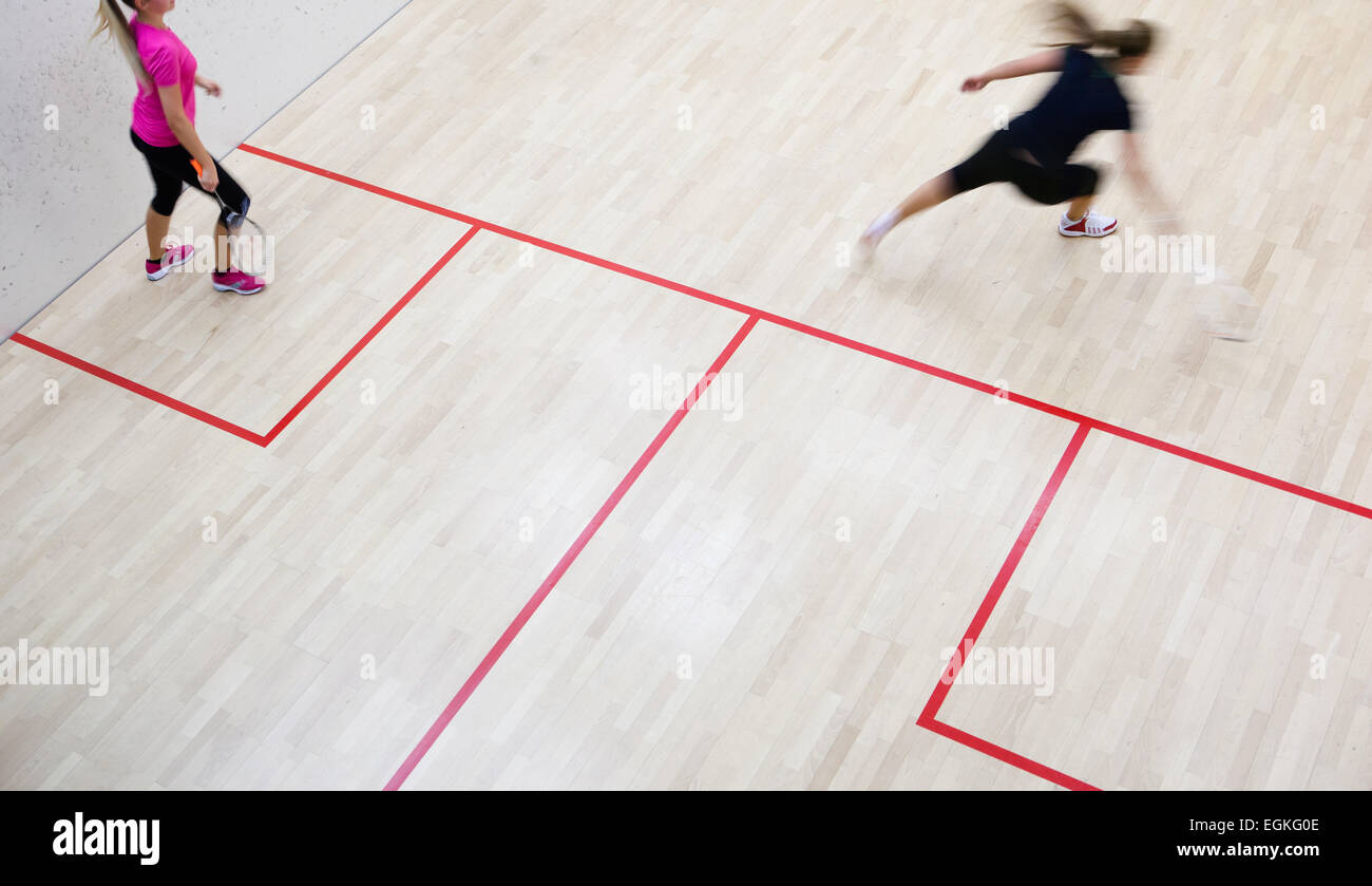 Two female squash players in fast action on a squash court (motion ...