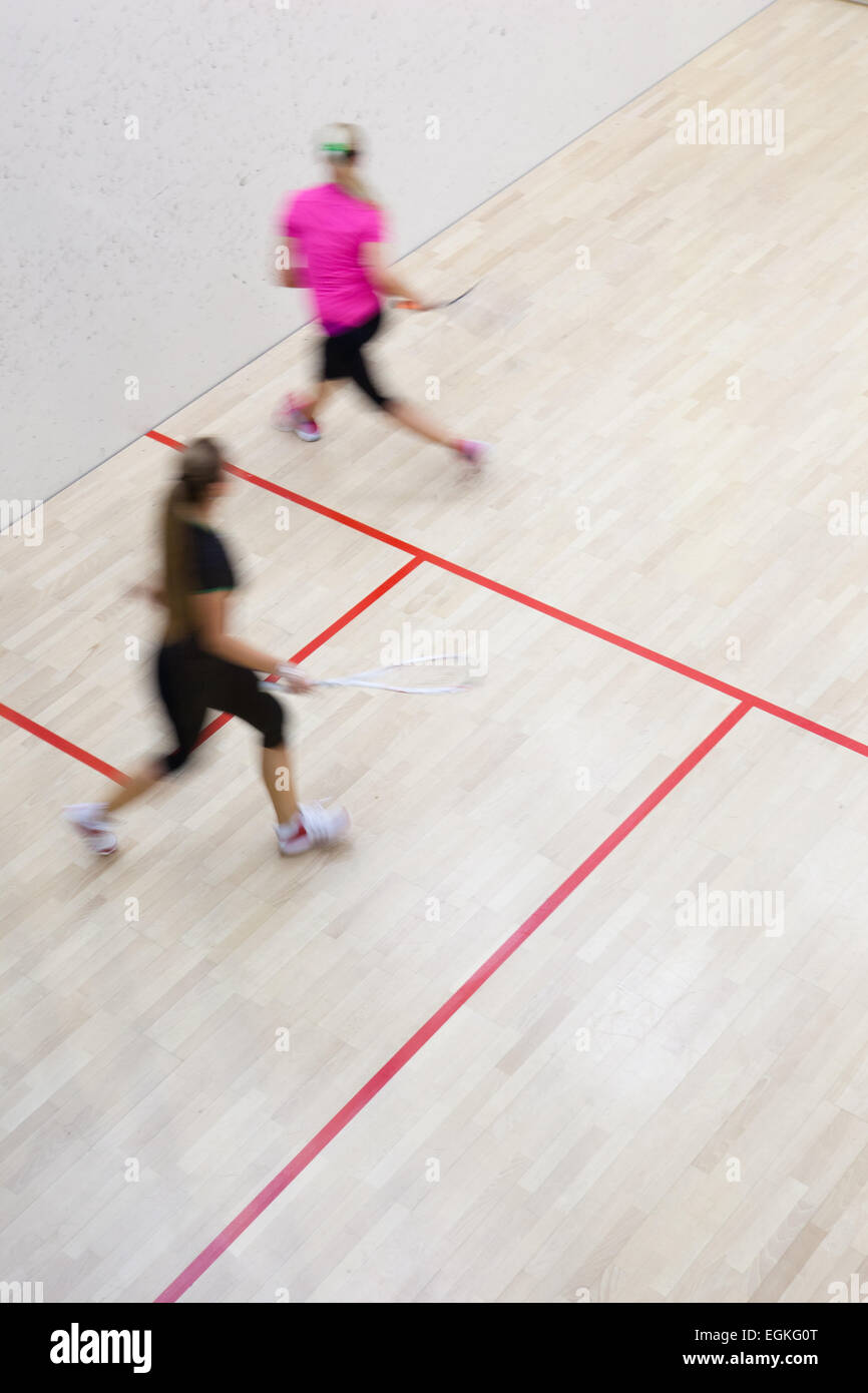 Two female squash players in fast action on a squash court (motion ...