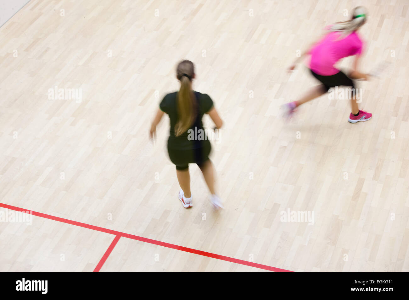 Two female squash players in fast action on a squash court (motion ...