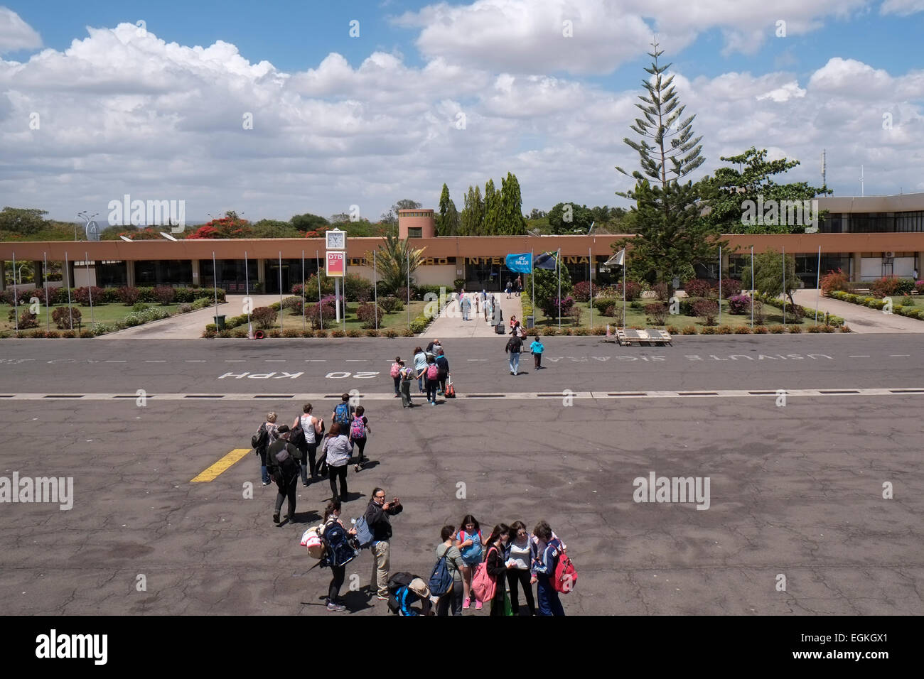 Arriving tourists walk toward the terminal of Kilimanjaro airport near ...