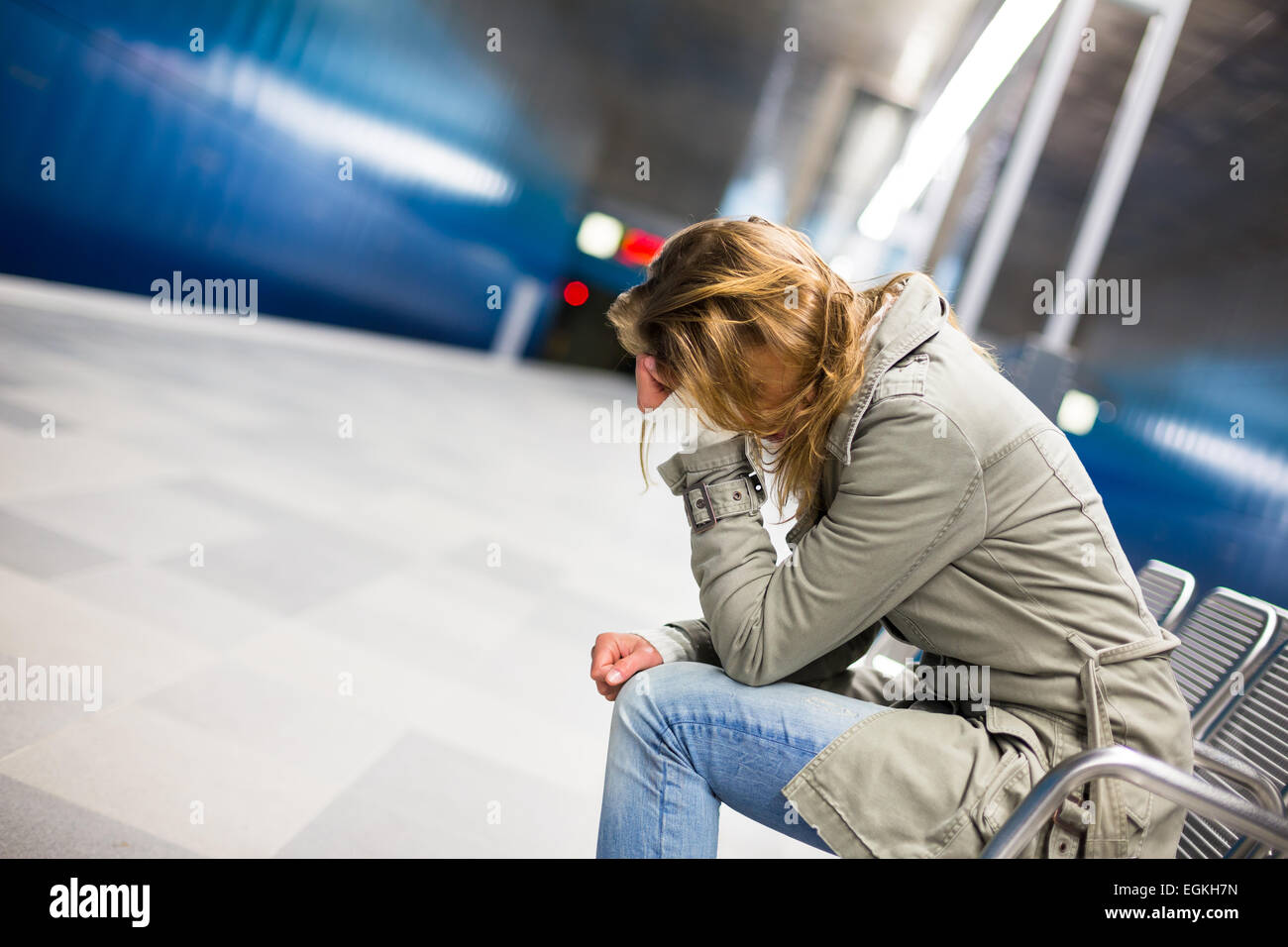 Sad and alone in a big city - Depressed young woman sitting in a metro ...