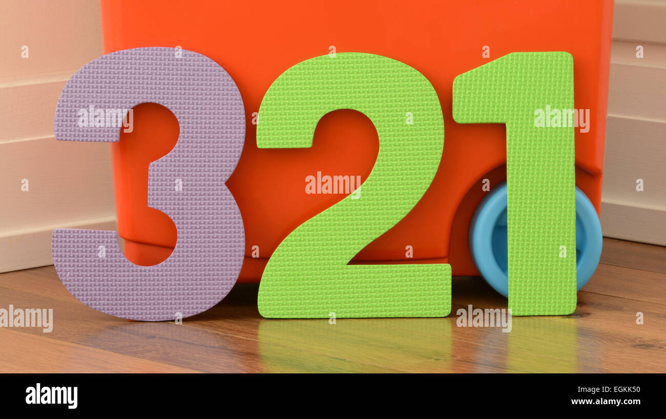 Colorful numbers 3,2,1 of flat foam toys on red plastic toy bin ...