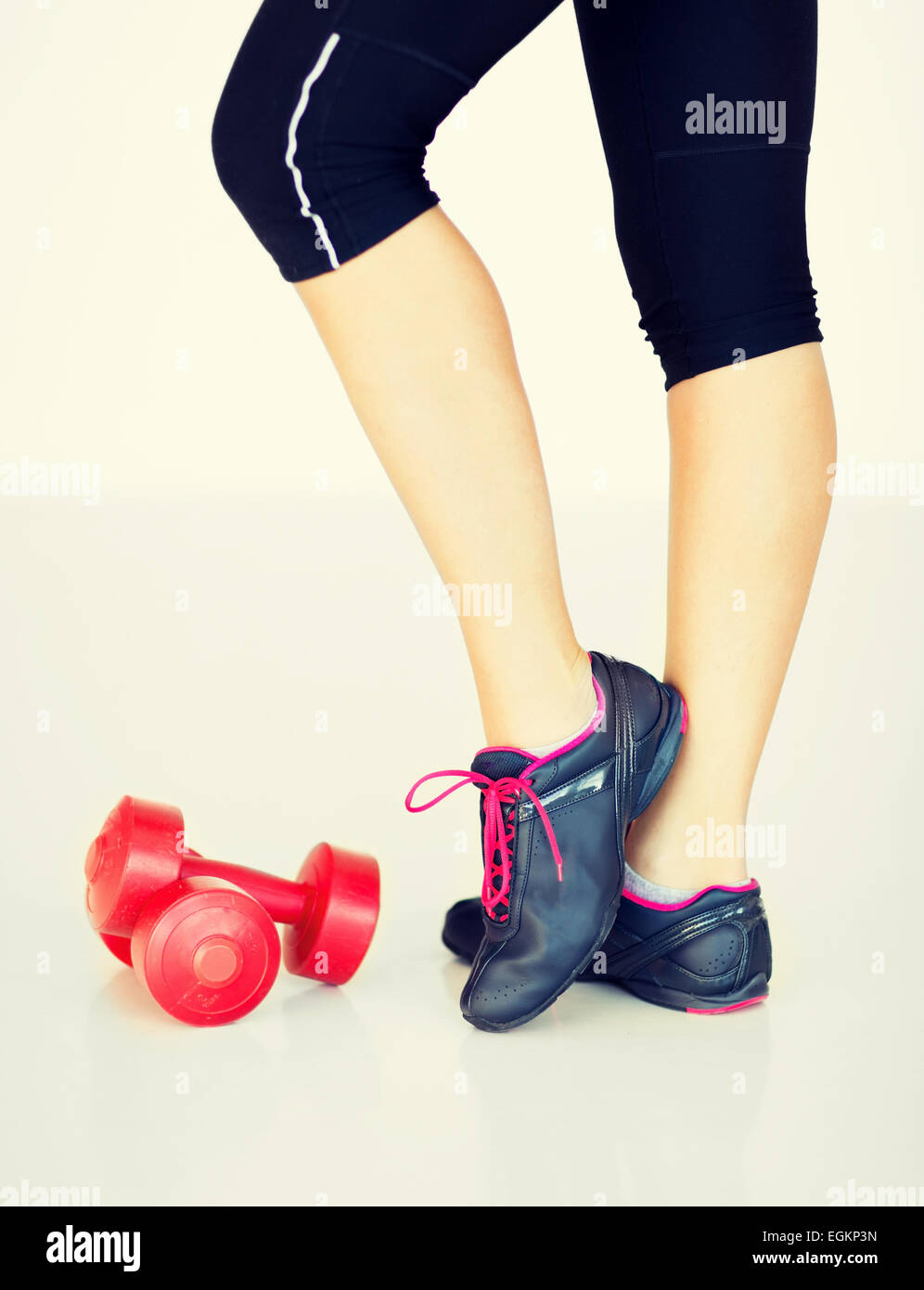 sporty woman legs with light red dumbbells Stock Photo - Alamy