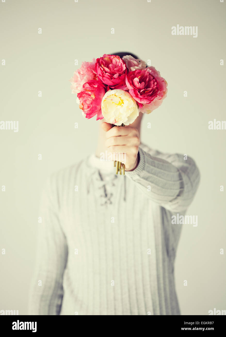 man covering his face with bouquet of flowers Stock Photo - Alamy