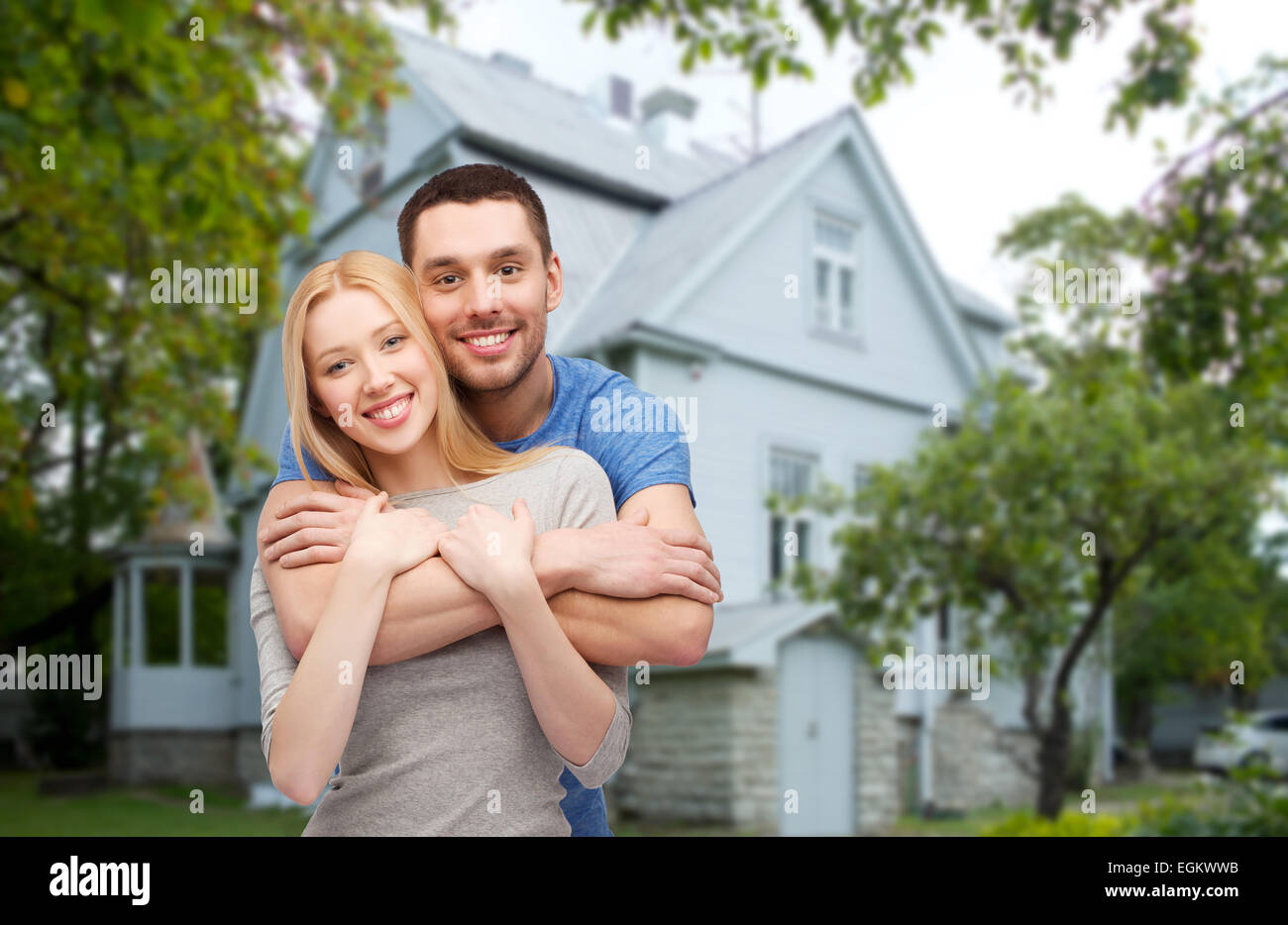 smiling couple hugging over house background Stock Photo - Alamy