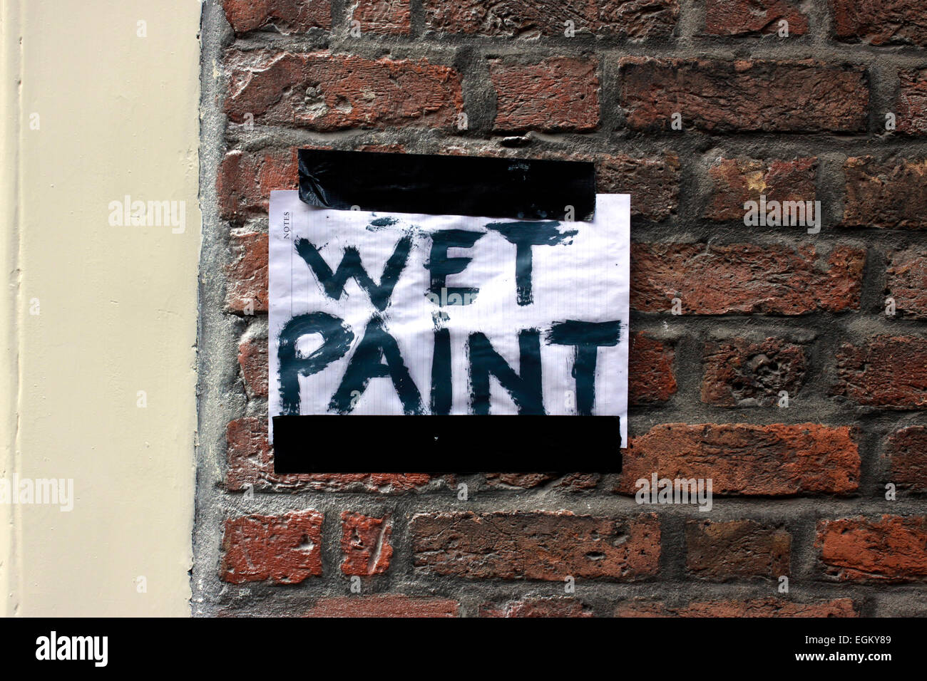A wet paint warning sign on a wall being decorated in London Stock ...