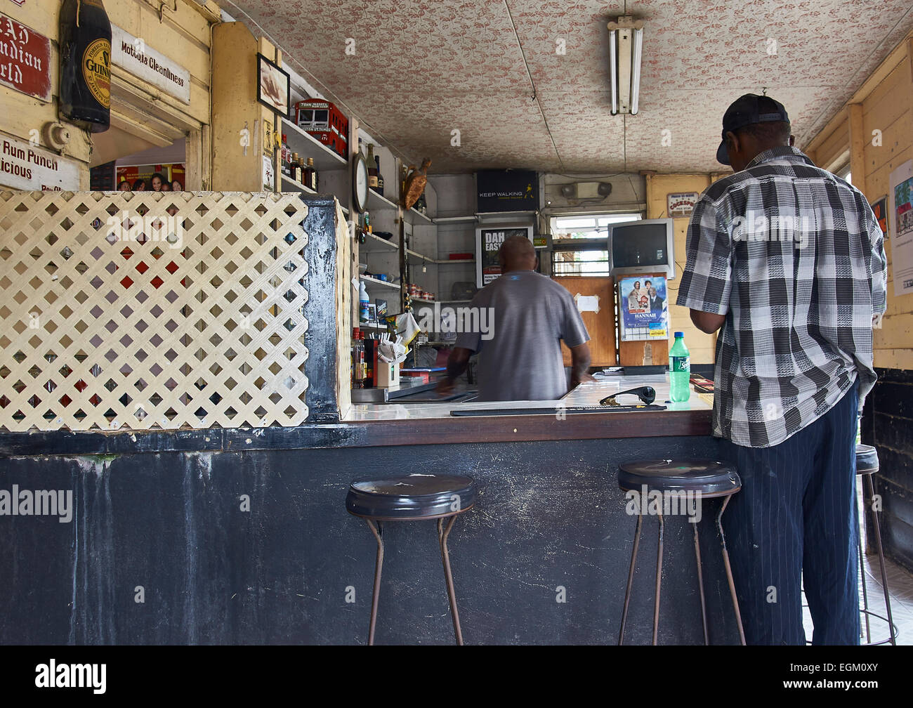 Barbados inside local bar, man behind counter standing, back to camera ...