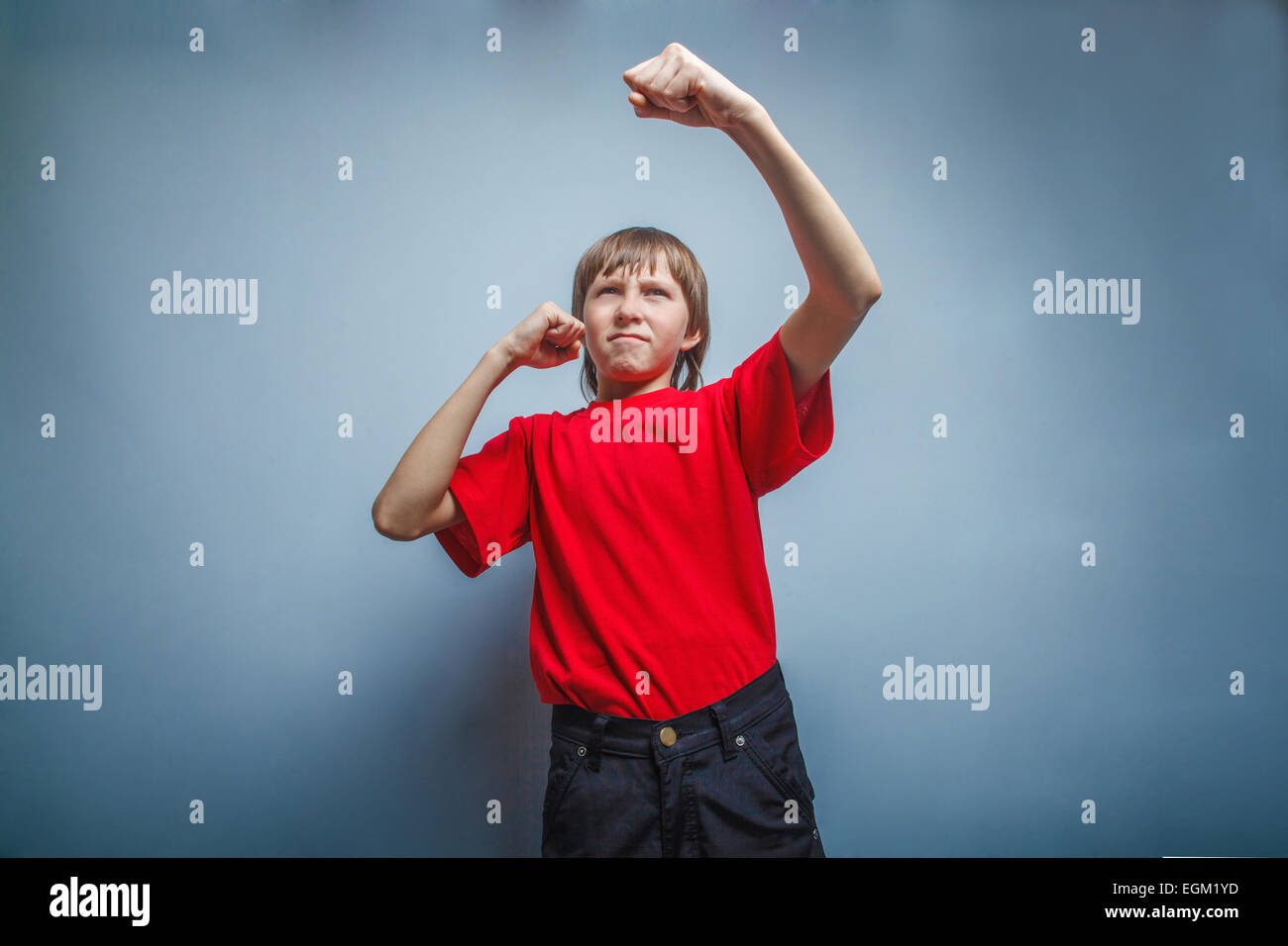 Boy, teenager, twelve years in red shirt, showing his fists Stock Photo ...