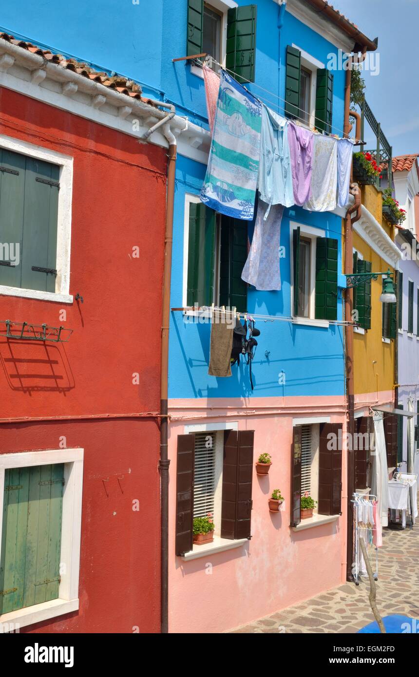 Laundry hanging on colorful buildings in Burano, an island of the ...