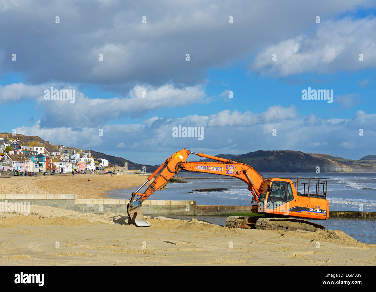 Levelling the beach at Lyme Regis with a JCB digger, Dorset, England UK ...