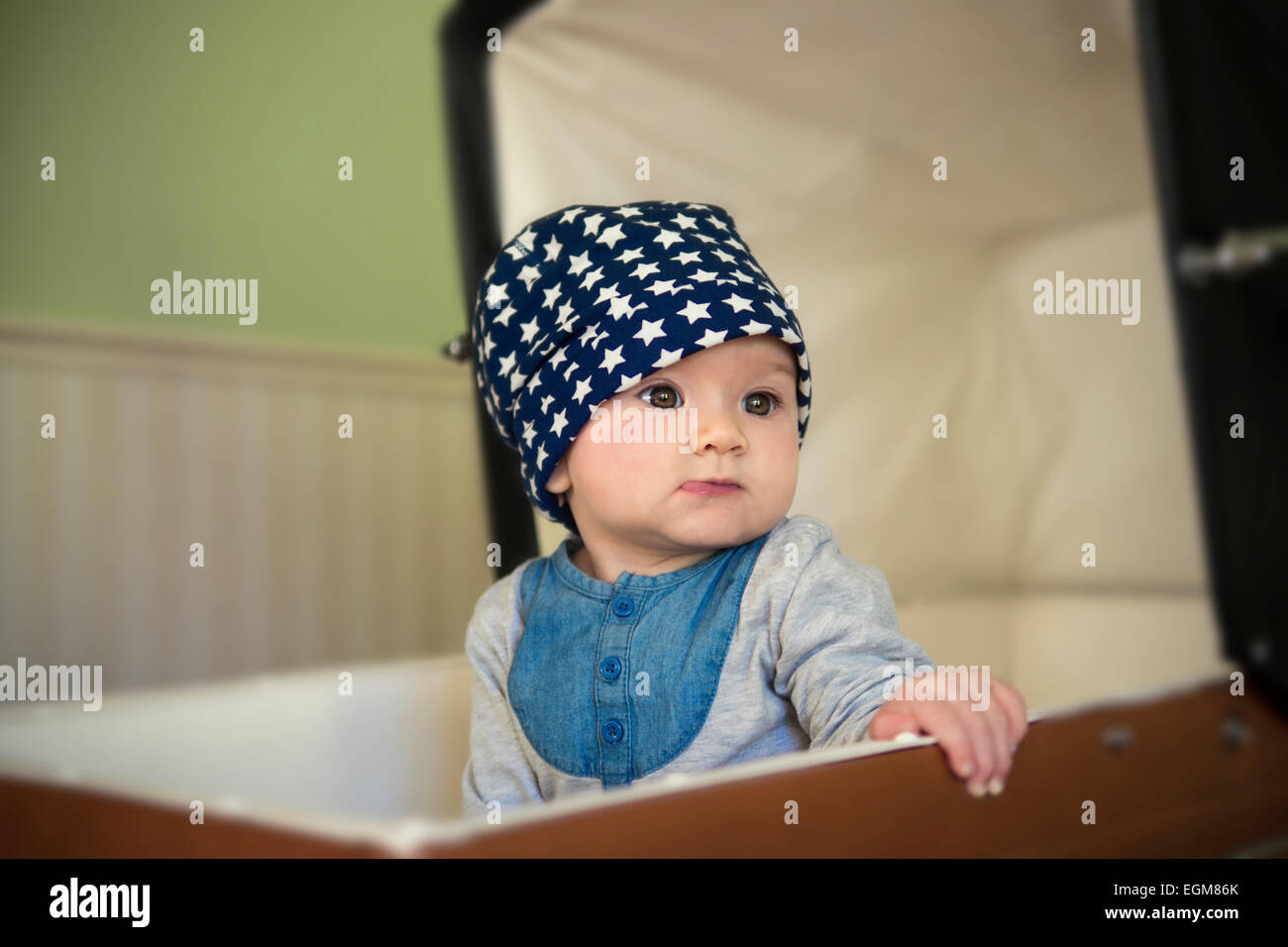 beautiful baby looking over the shoulder sitting in a retro stroller ...