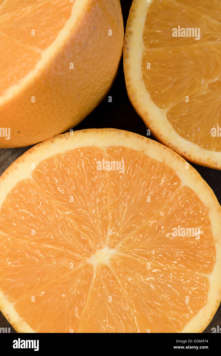 fresh ripe cutted oranges on a wood background Stock Photo - Alamy