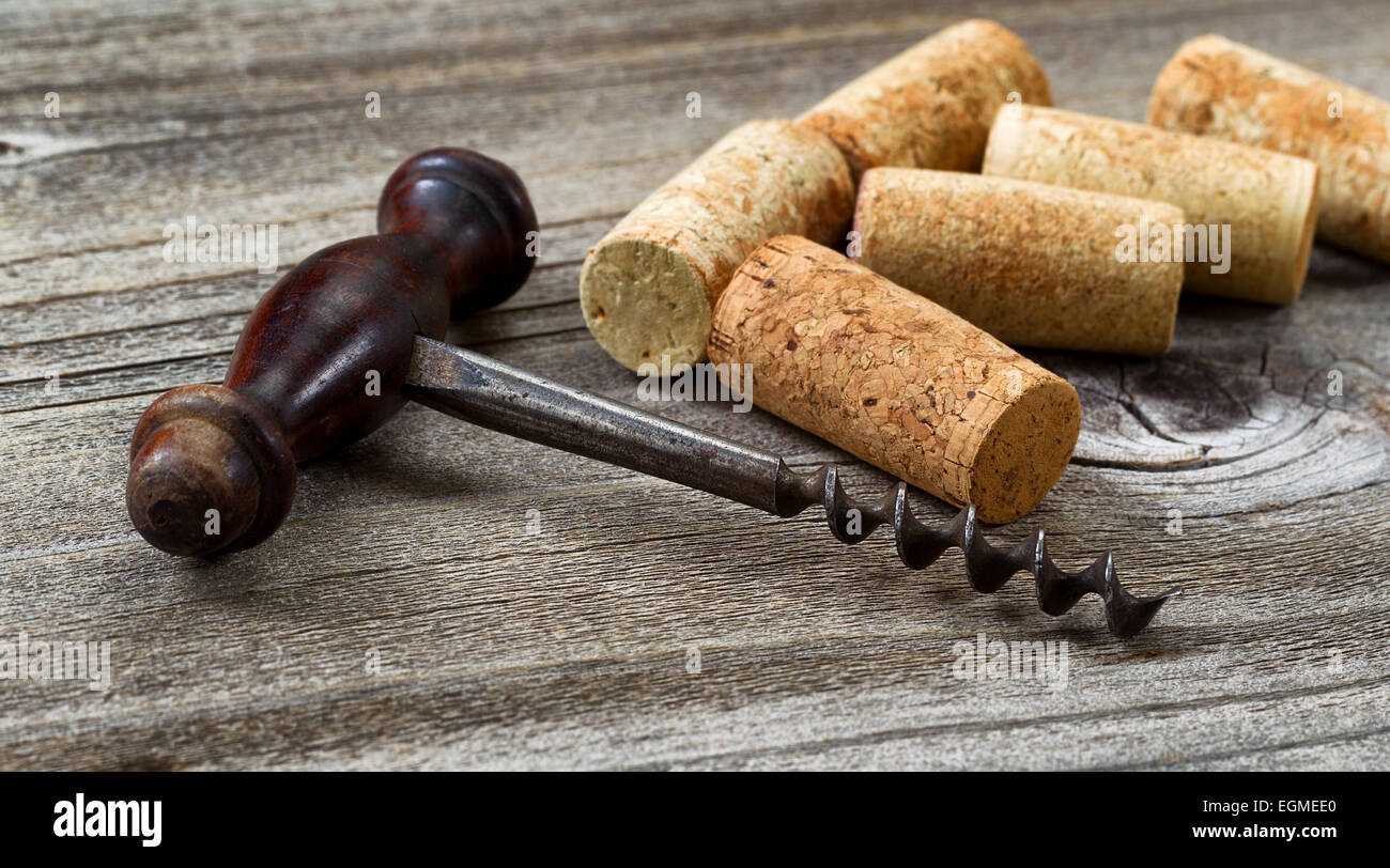 Close up front view of antique corkscrew with used corks in background ...