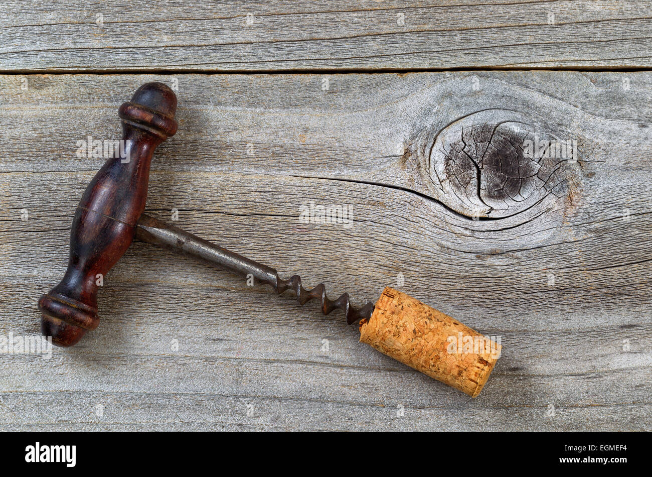 Top view angled shot of vintage corkscrew with attached cork on rustic ...