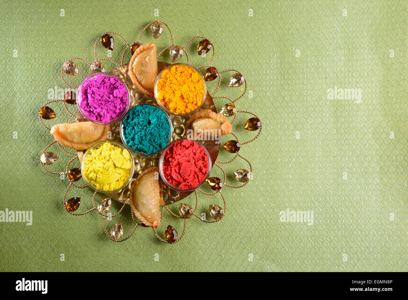 Gujia is a cuisine of India surrounded by colorful gulaal in the bowls ...