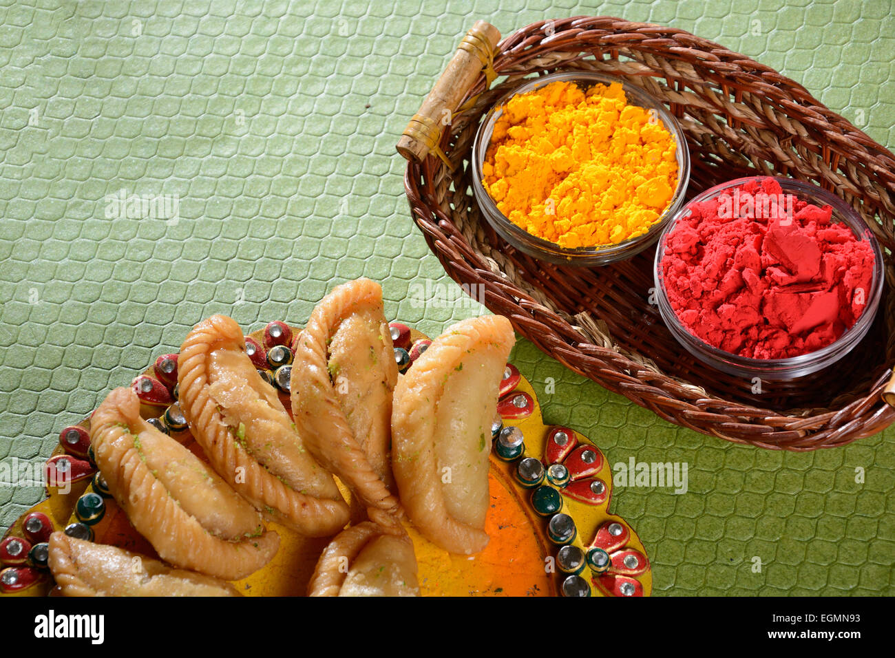 Gujia is a cuisine of India surrounded by colorful gulaal in the bowls ...