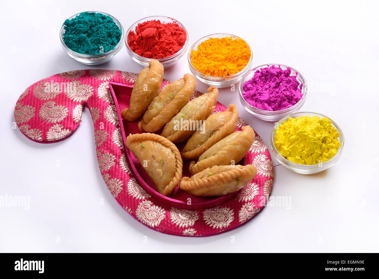 Gujia is a cuisine of India surrounded by colorful gulaal in the bowls ...