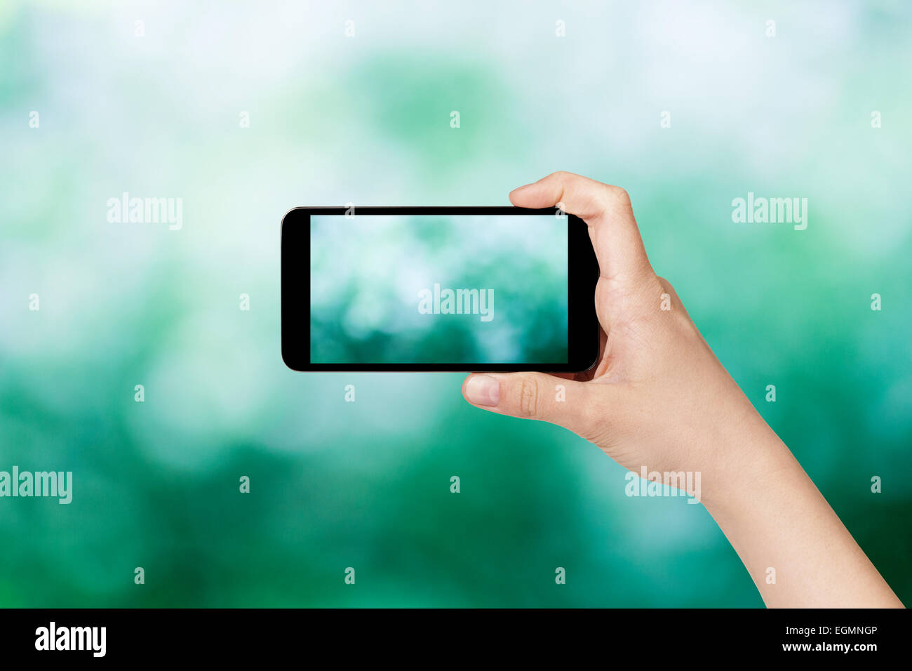 female teen hand taking picture with smart phone of green Stock Photo ...