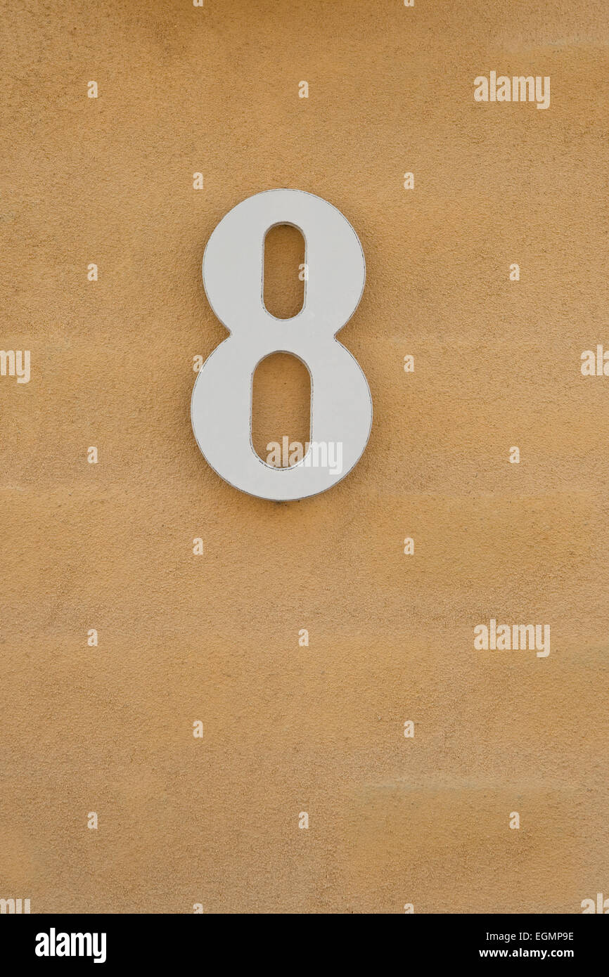 Number 8 on a yellow plastered wall Stock Photo - Alamy