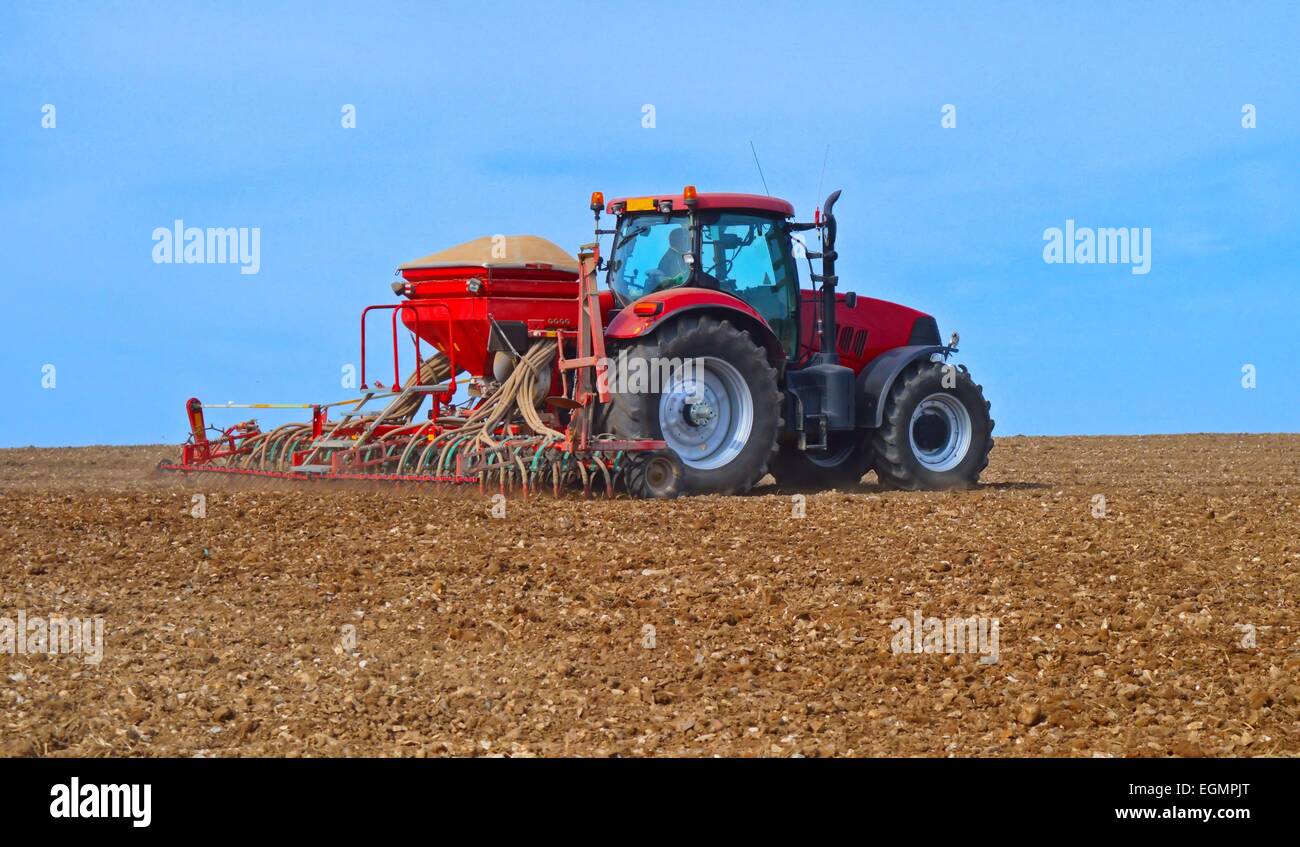 Red tractor drilling seeds to grow before harvest Stock Photo - Alamy
