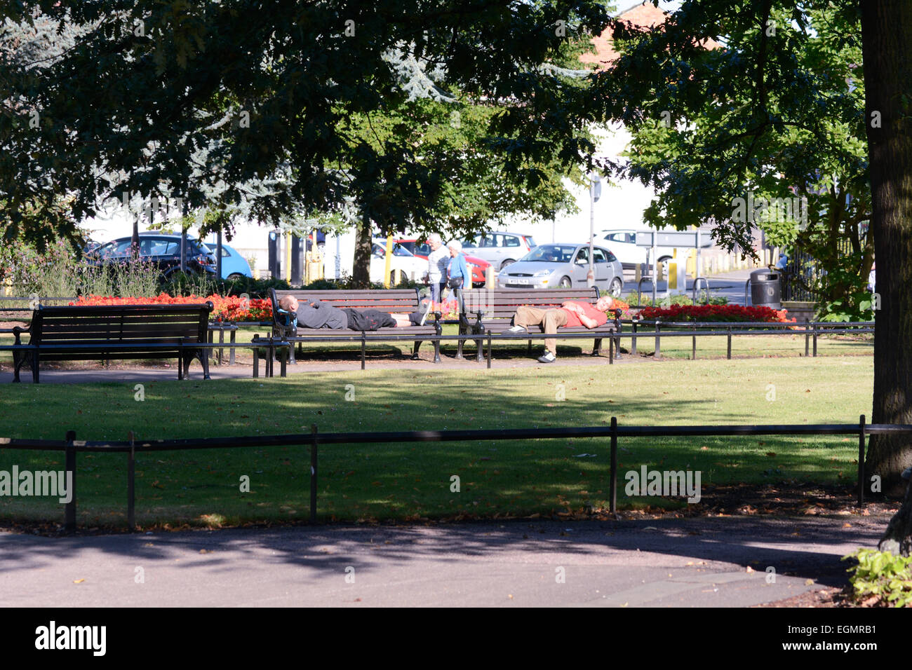 Two men laying on park benches sleeping off hangovers in Bedford ...