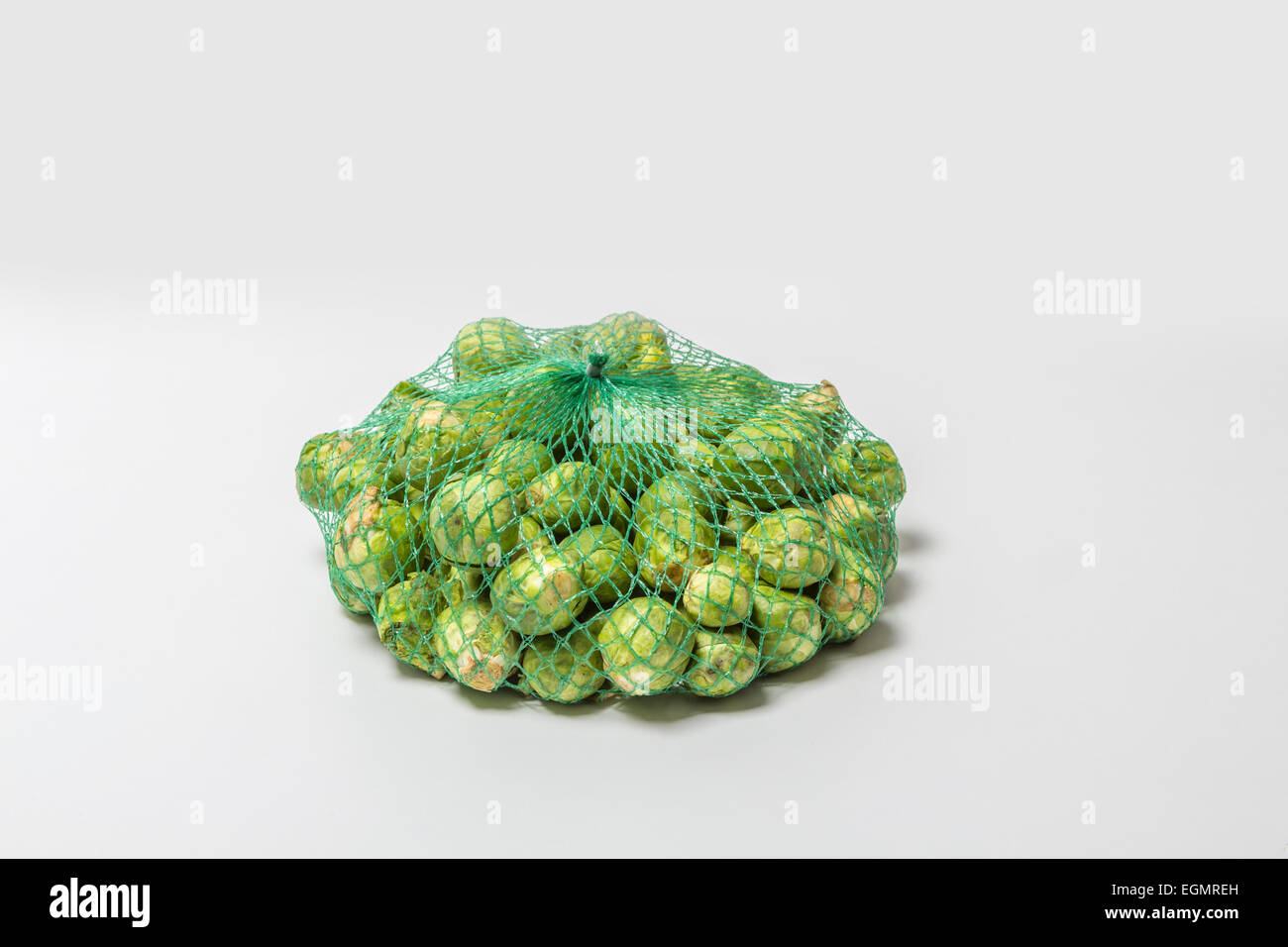 Brussels sprouts in a net on white background Stock Photo - Alamy