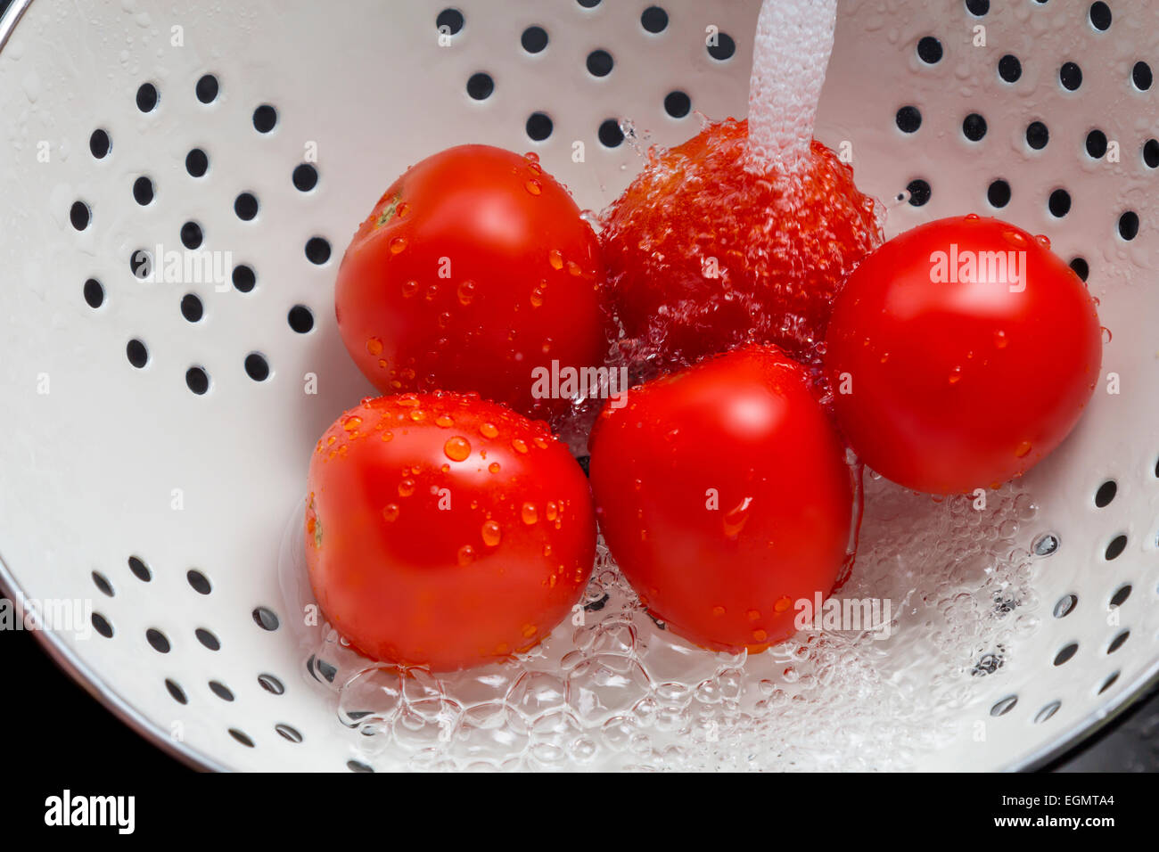 Fresh Tomatoes beeing washed in a white sieve Stock Photo - Alamy