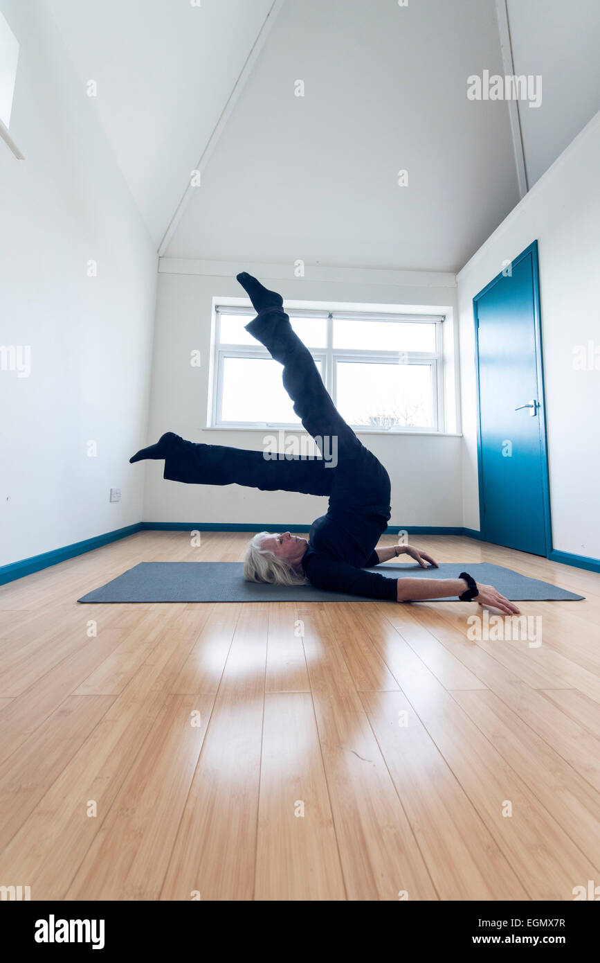 elderly older lady practicing palates yoga and keeping active while ...