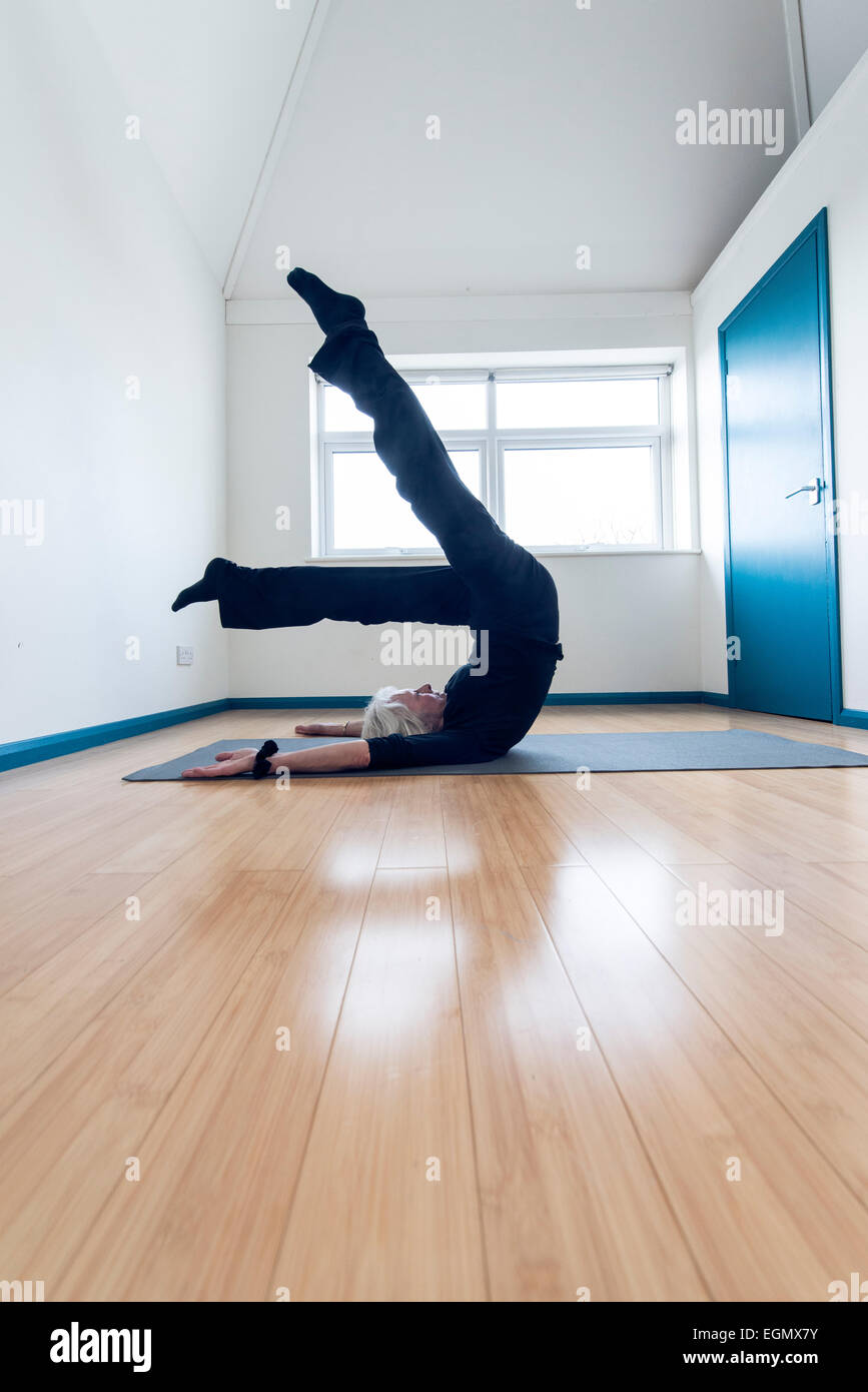 elderly older lady practicing palates yoga and keeping active while ...