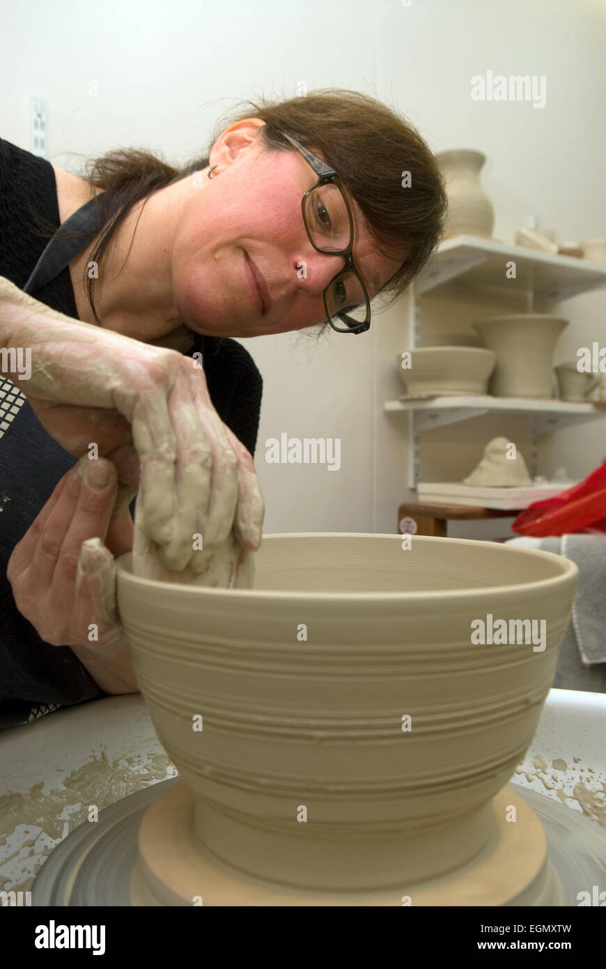 Ceramics tutor at an adult learning centre demonstrating throwing on ...