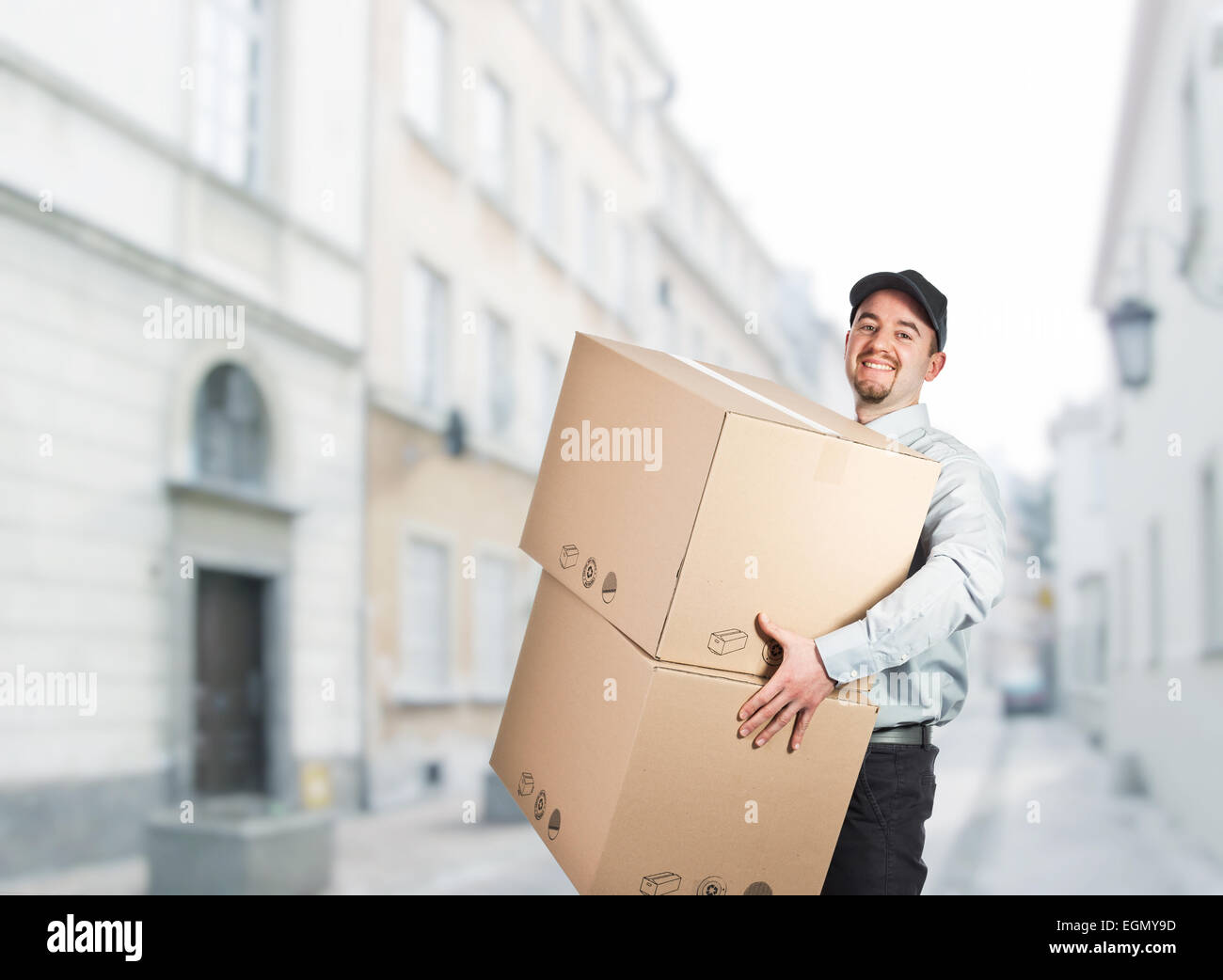 smiling delivery man with boxes Stock Photo - Alamy