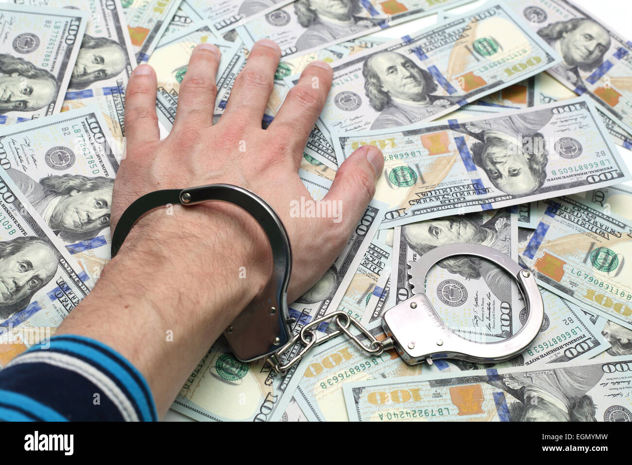 Hand in handcuffs on a pack of dollars Stock Photo - Alamy