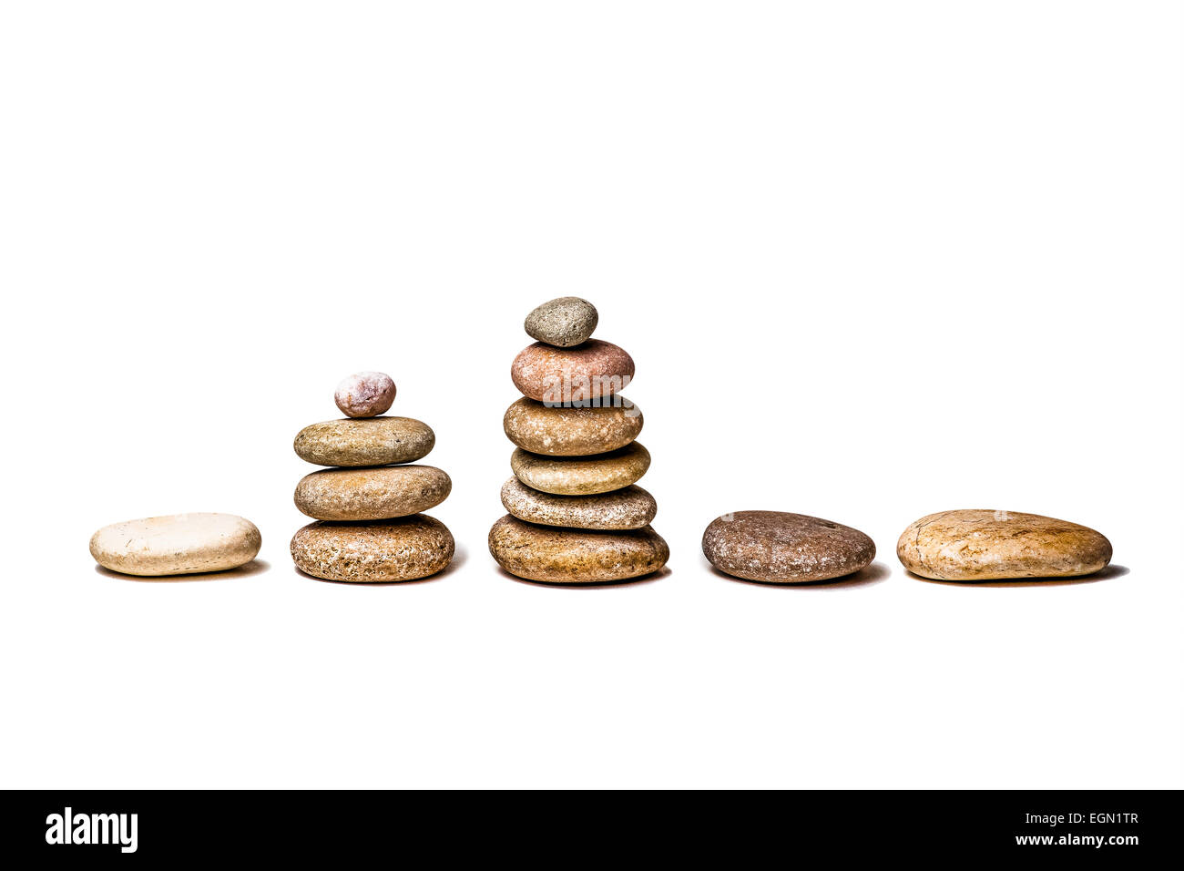 A horizontal line of five brown pebbles and two stacks of pebbles ...
