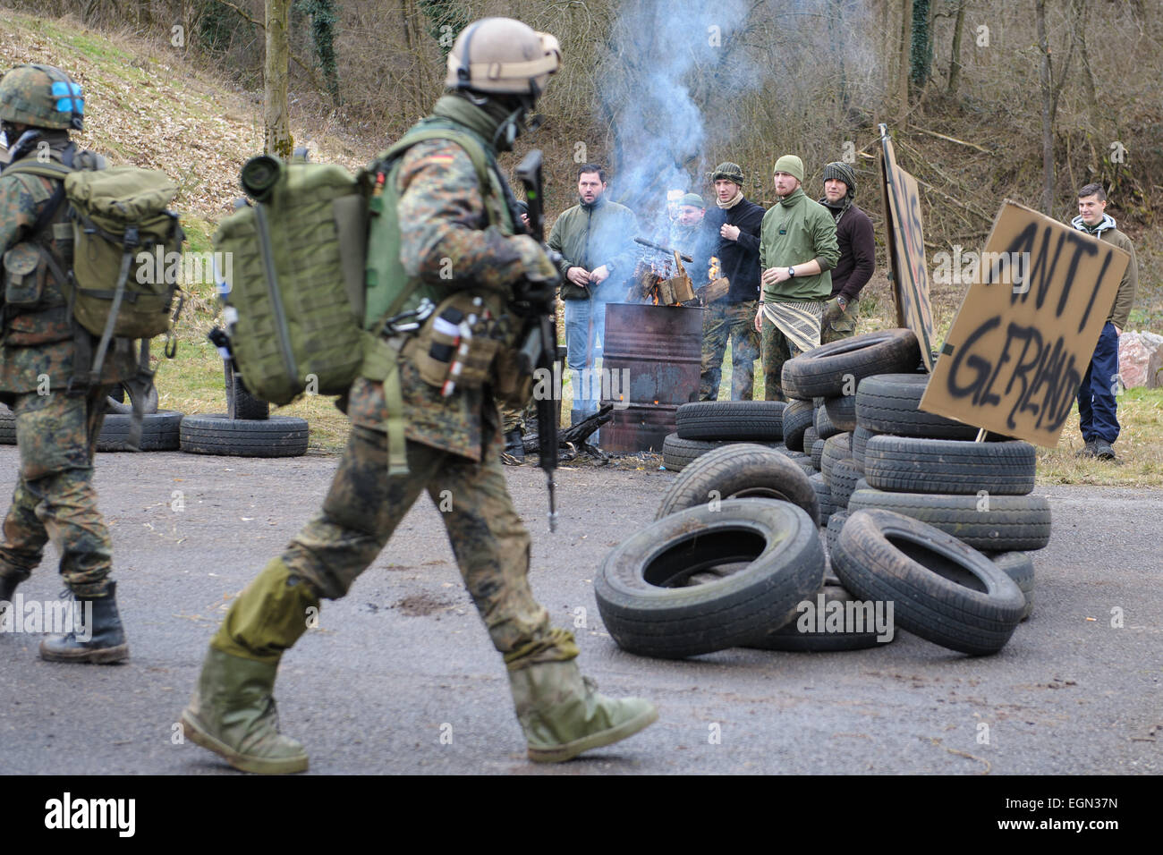 Troops of the 26th Airborne Brigade pass a roadblock occupied by extras ...