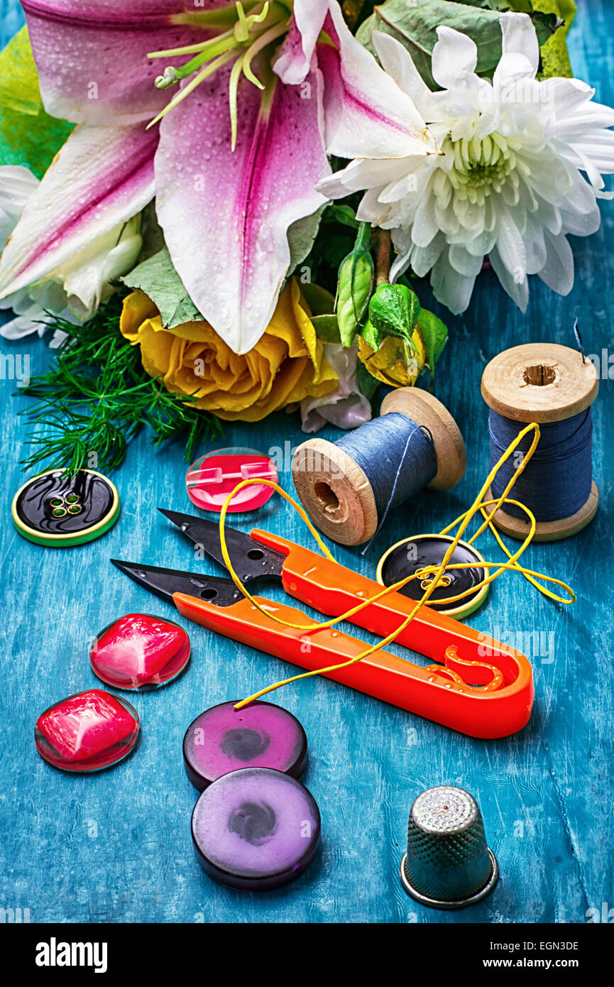 sewing accessories with a bouquet of fresh flowers on turquoise ...