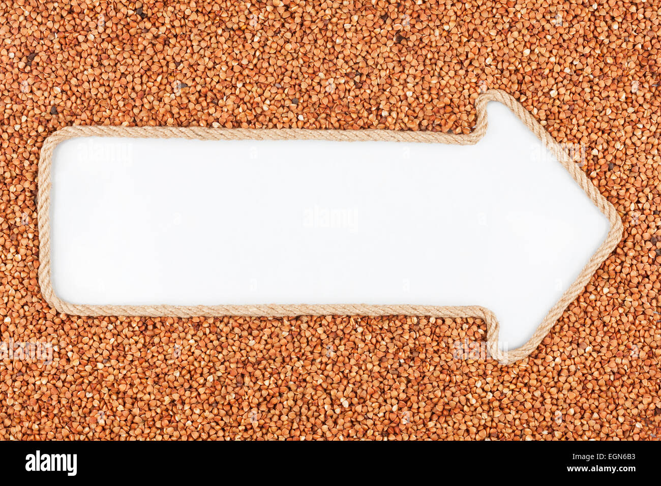 Arrow made of rope and buckwheat with a white background and with place ...