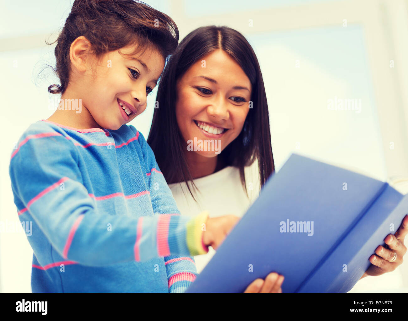 mother and daughter with book Stock Photo - Alamy