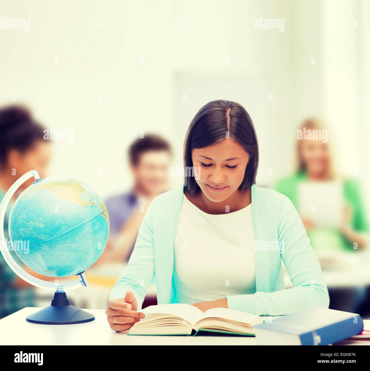 teacher with globe and book at school Stock Photo - Alamy