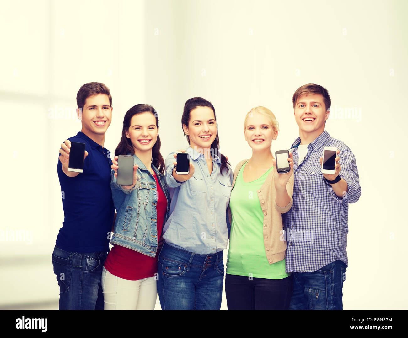 students showing blank smartphones screens Stock Photo - Alamy