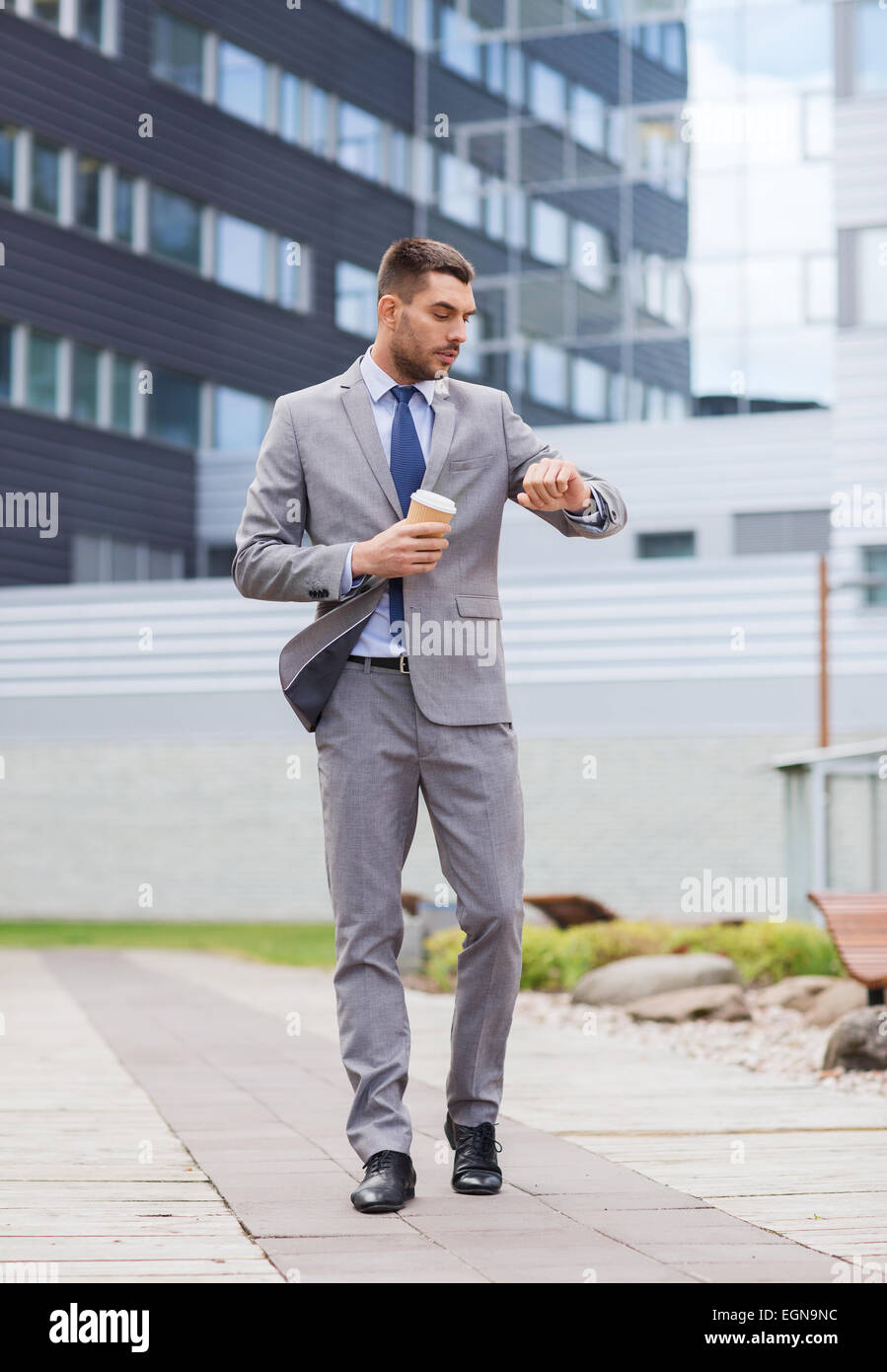 young serious businessman with paper cup outdoors Stock Photo - Alamy
