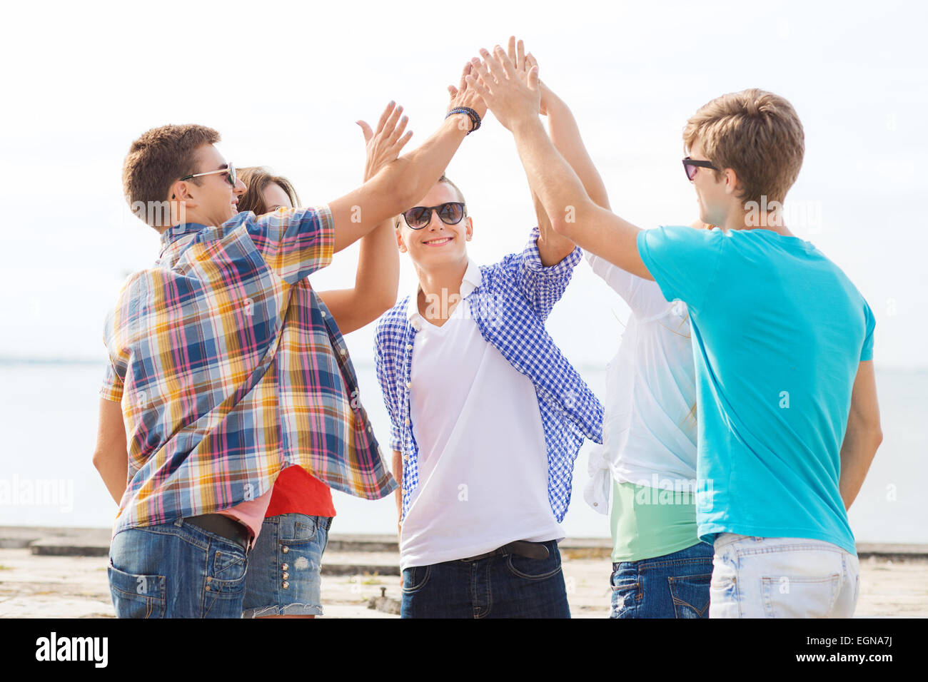 group of smiling friends making high five outdoors Stock Photo - Alamy