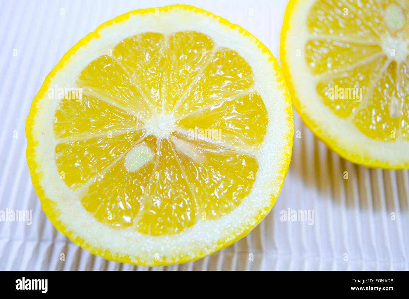 Halved lemon on a white cardboard close up Stock Photo - Alamy