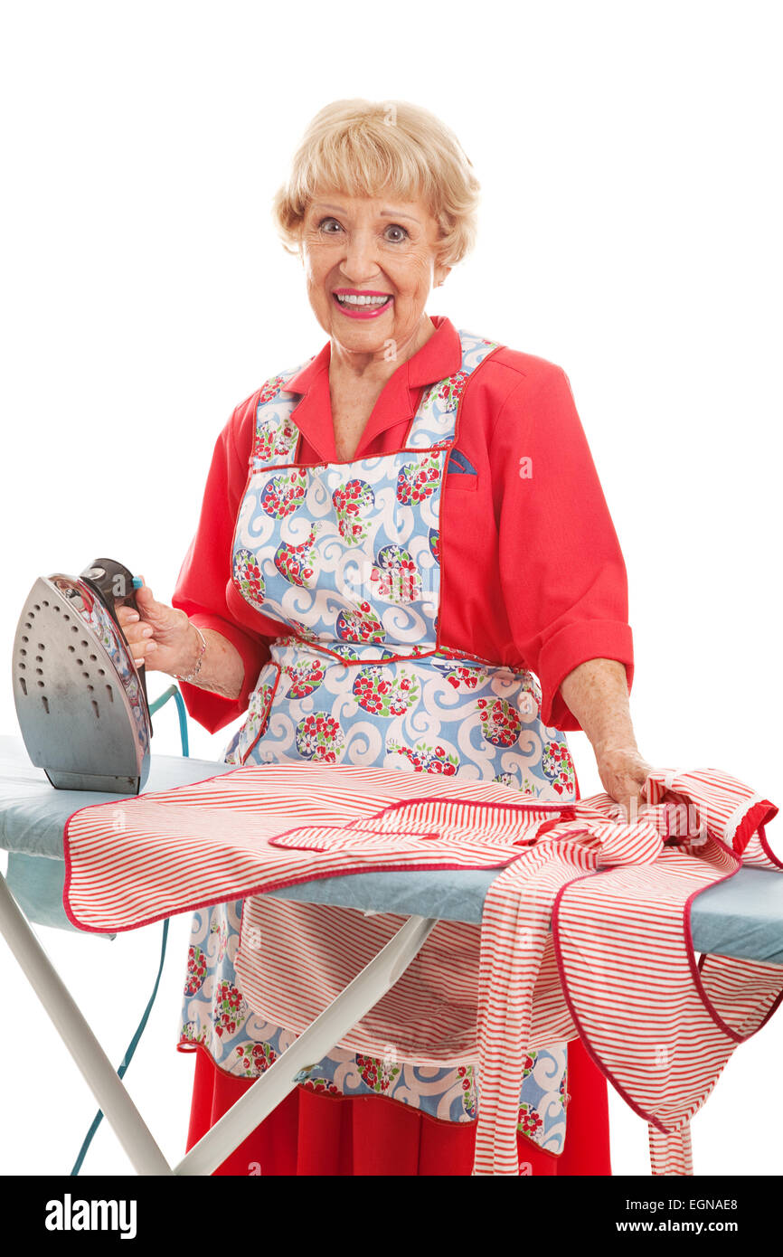 Sweet old lady in retro apron doing the ironing. Isolated on white ...