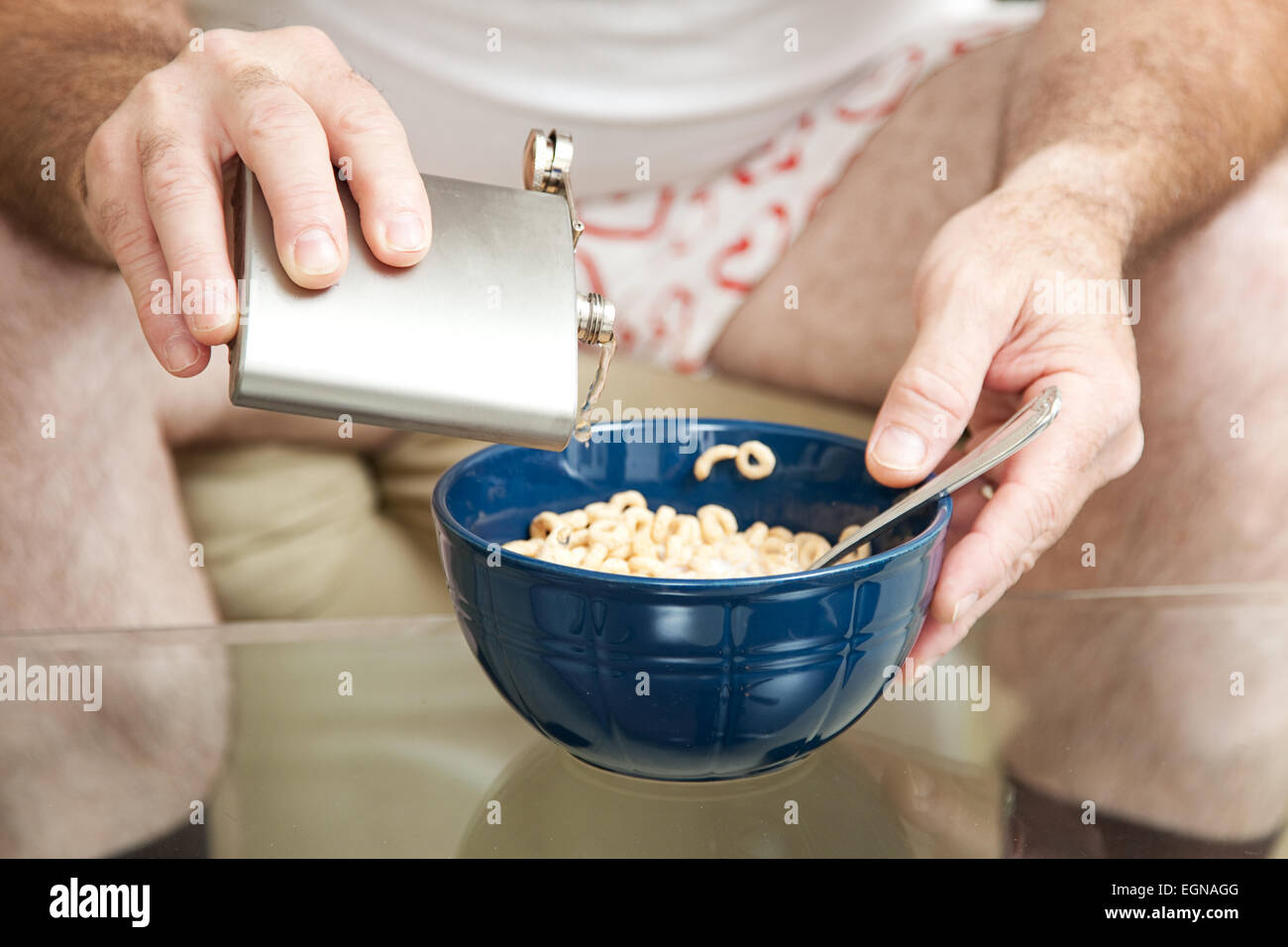 Alcoholic spiking his cereal with vodka from a flask. Shallow depth of ...