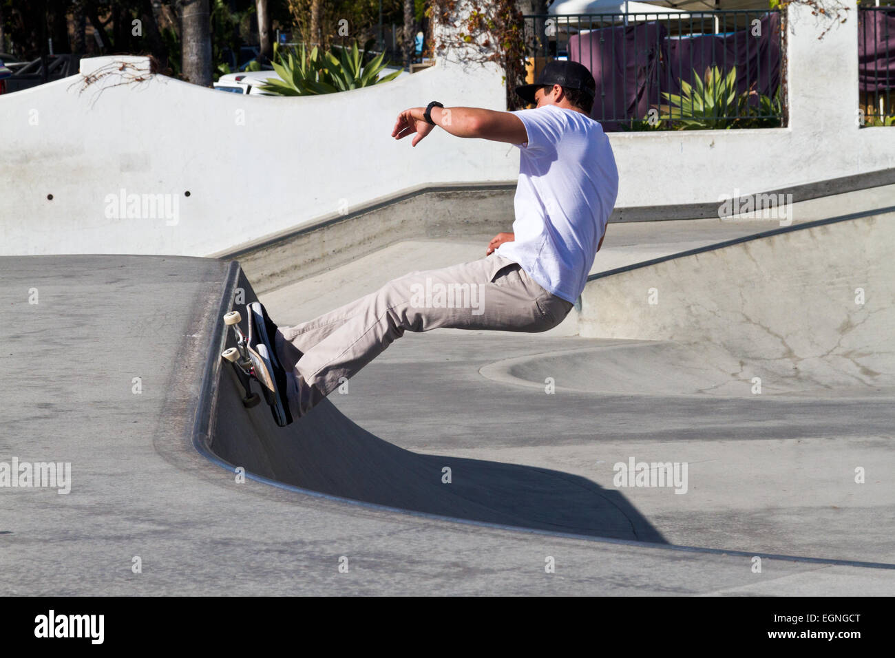 A young man performing a stunt on a skateboard at a skate park in Santa ...